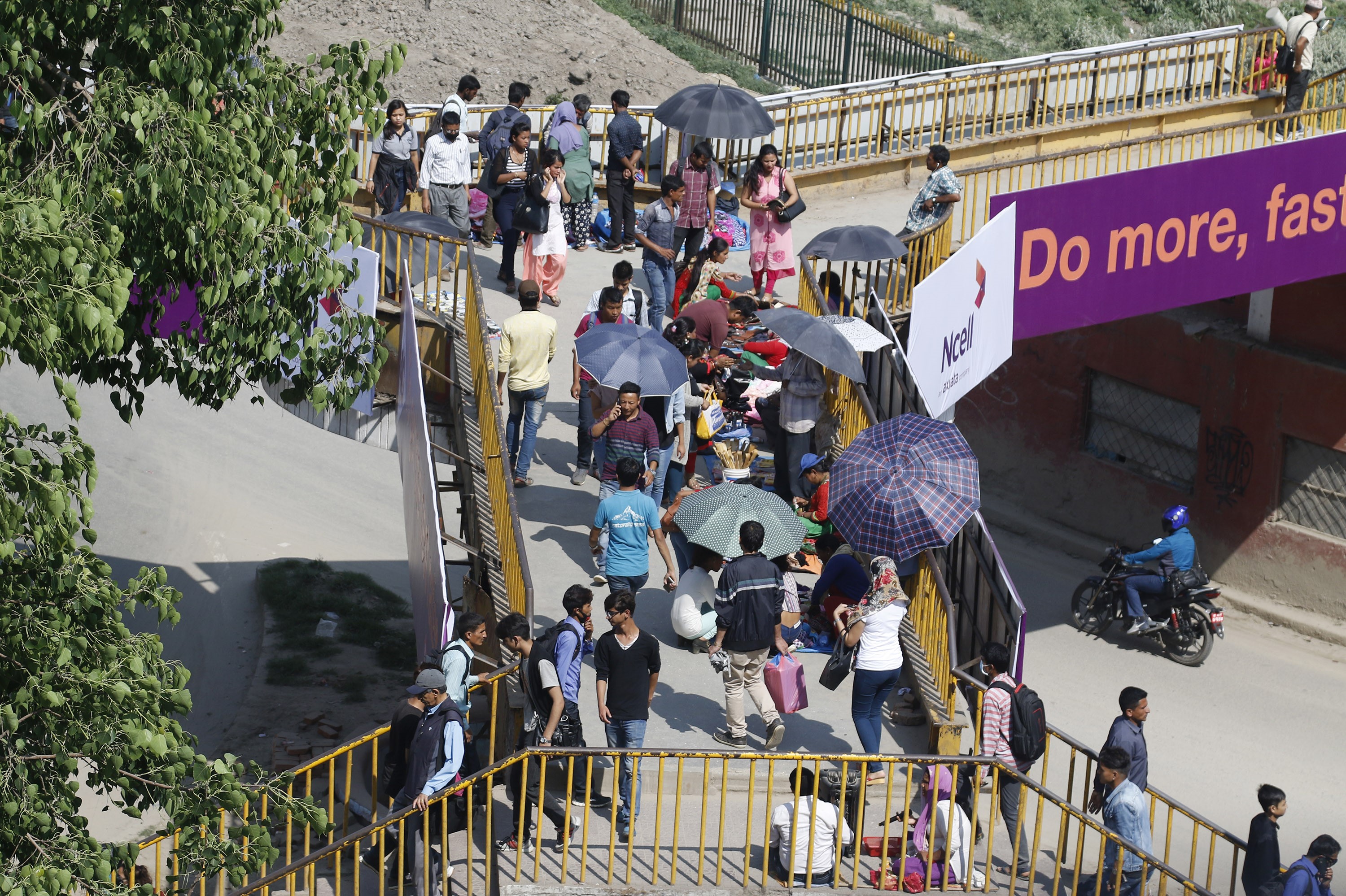 This is how people spend their day on Kathmandu’s overhead bridges