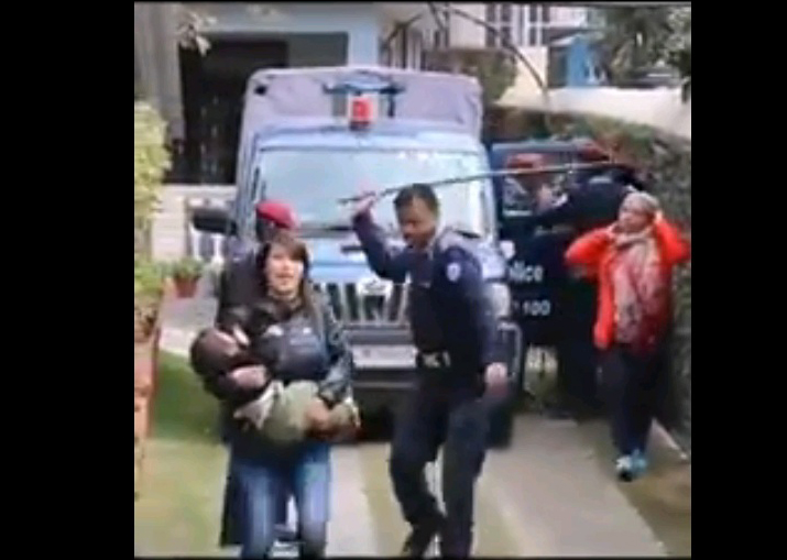 Video of police officer baton charging a woman carrying a child ...